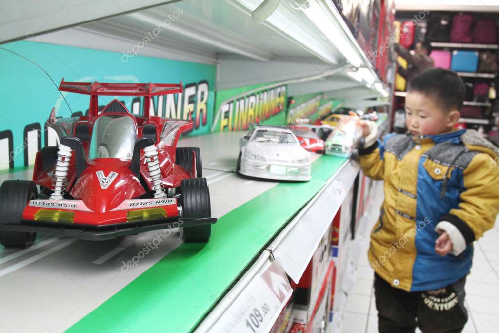 --FILE- Un niño chino mira a los niños coches de juguete en un centro ...