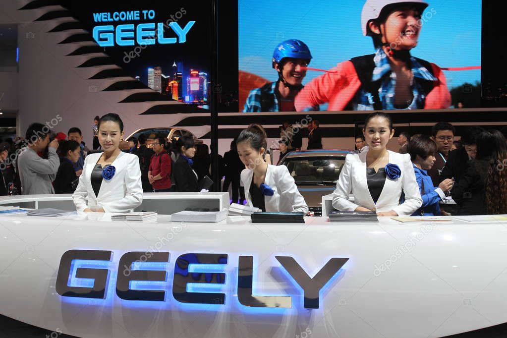 Miembros del personal chino se ven en el stand de Geely durante la 15ª ...