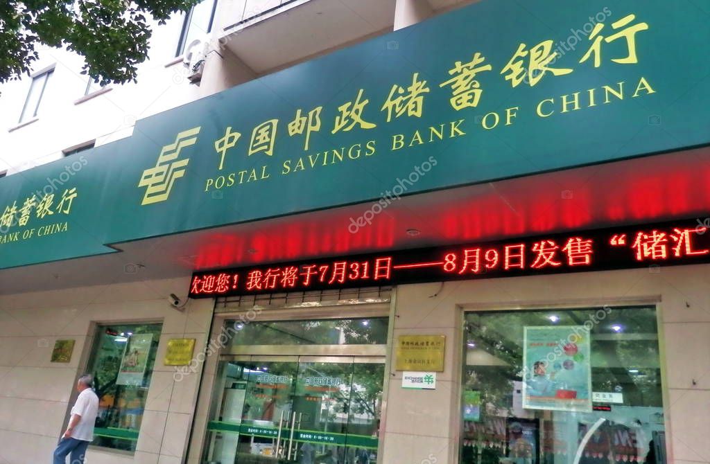Un peatón pasa por una sucursal de Postal Savings Bank of China (PSBC ...