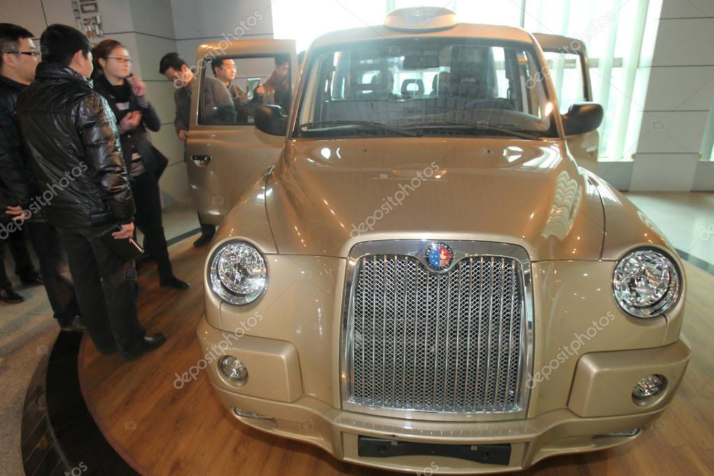 Los visitantes observan un Geely Englon TX4 en una planta automotriz de ...