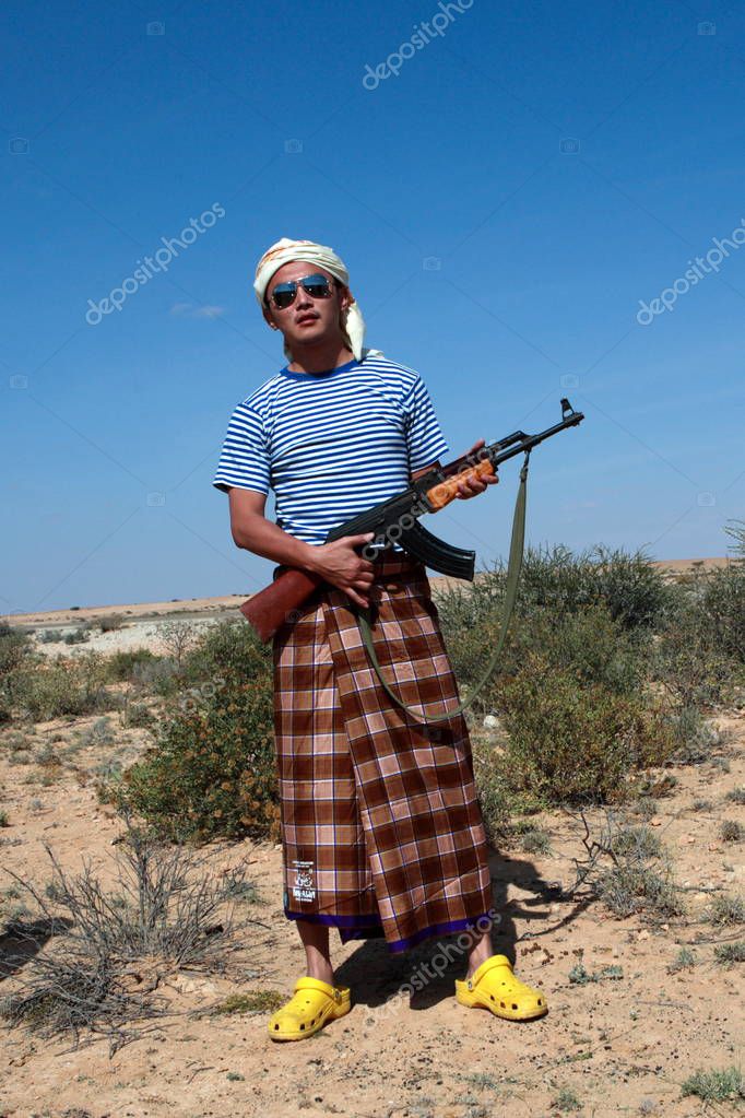 El reportero chino Zeng Yu sosteniendo una ametralladora posa para las ...