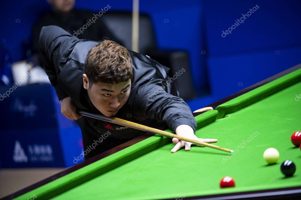 El jugador de billar profesional chino Yan Bintao juega una oportunidad ...