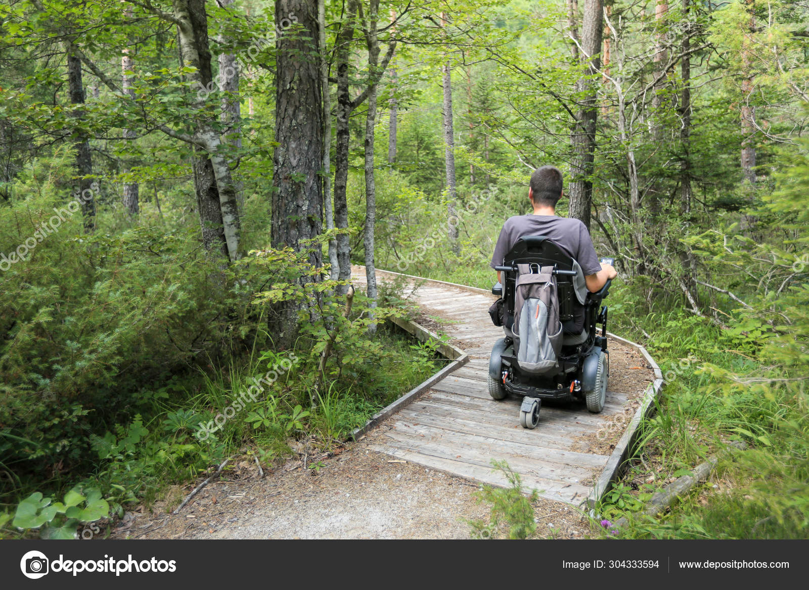 Man on a wheelchair in a forest. — Stock Photo © 24K-Production #304333594