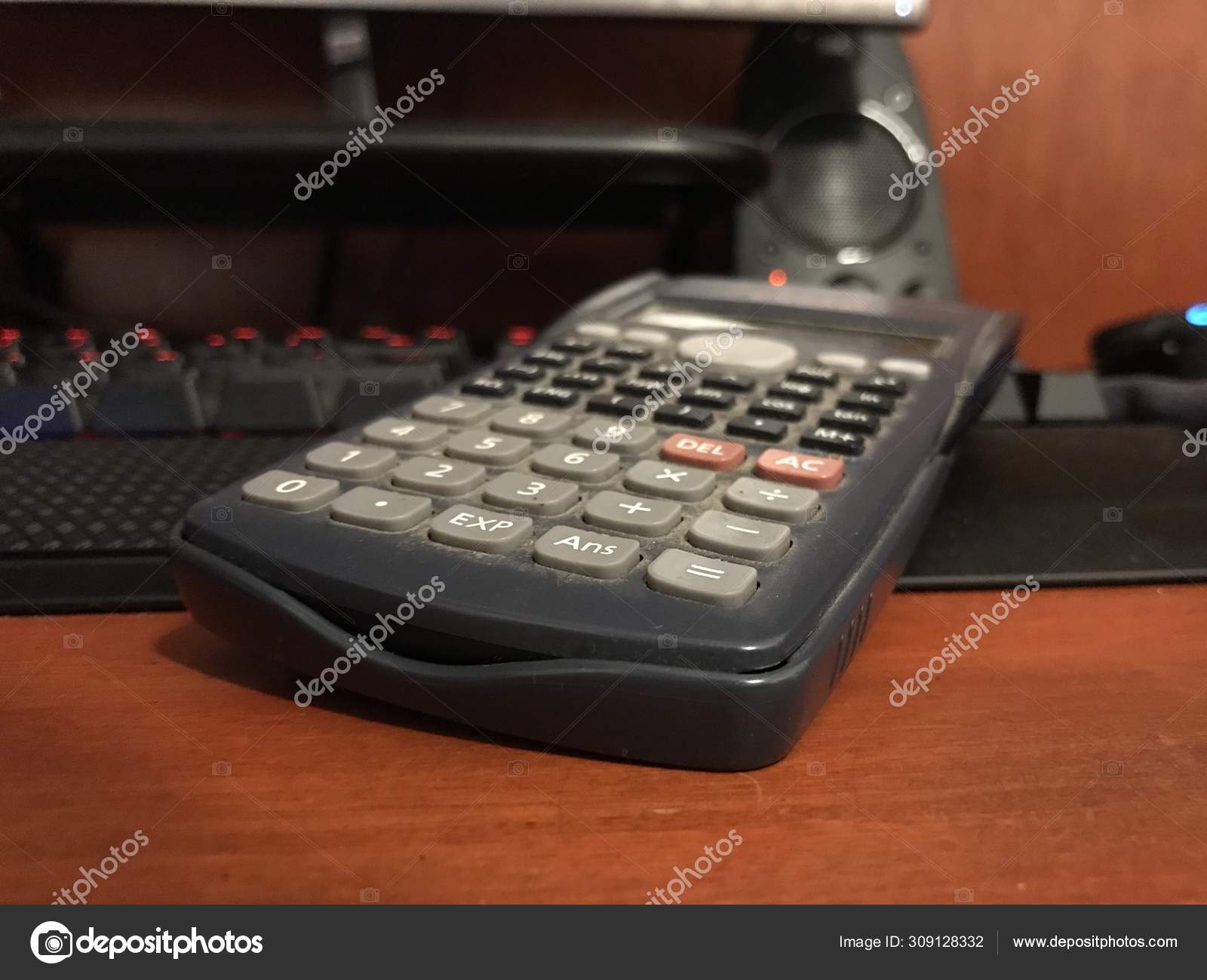 Scientific calculator over a computer keyboard on a wooden desk — Stock ...
