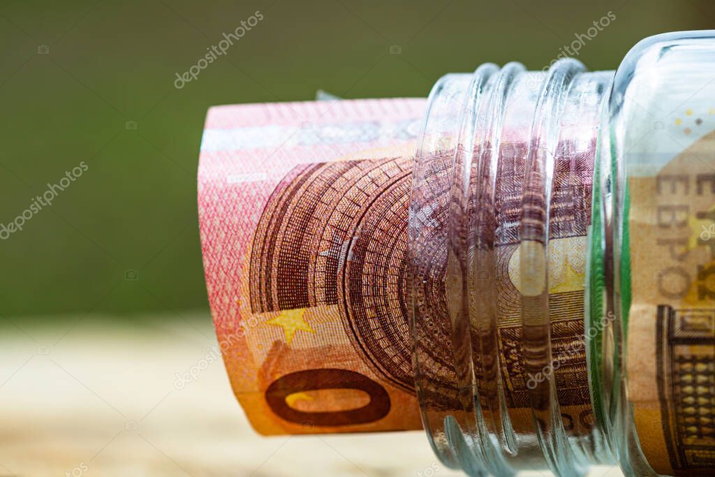 Composición con el ahorro de billetes de dinero en un frasco de vidrio ...
