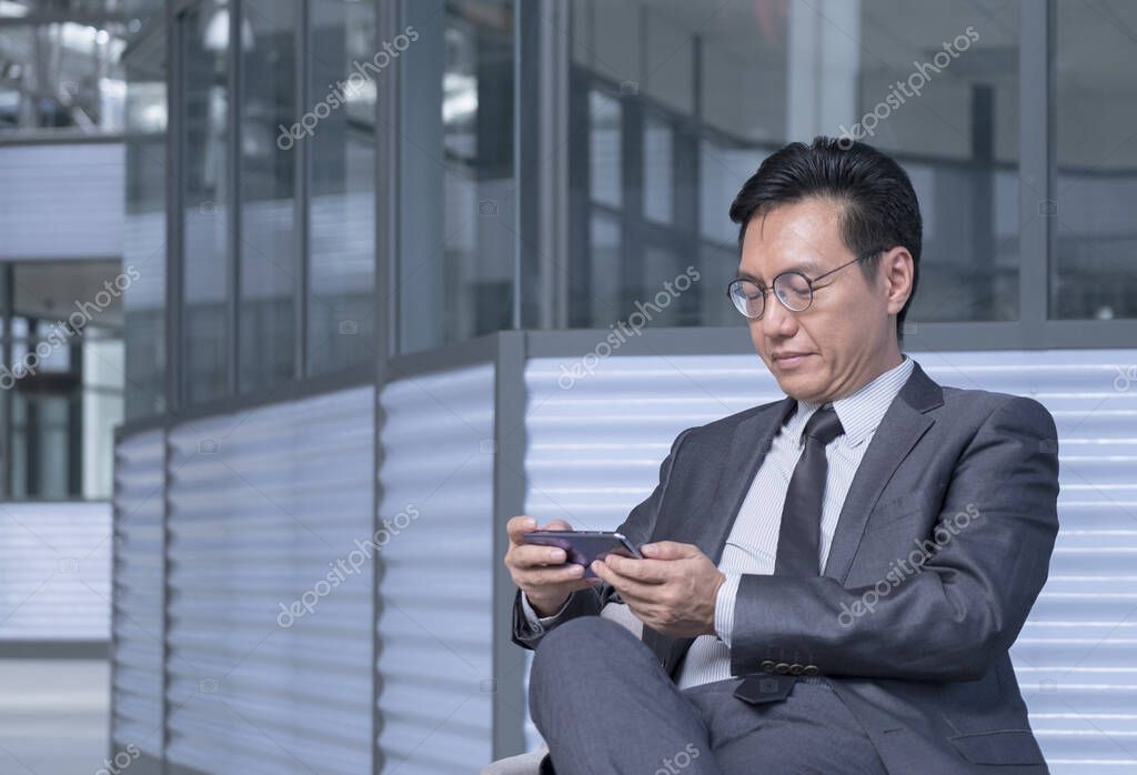 Hombre de negocios chino con traje y corbata usando el teléfono celular ...