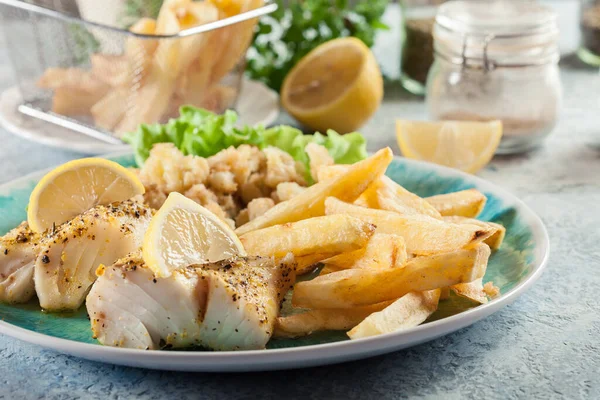 Steamed cod fish with french fries and boiled cauliflower on a plate ...