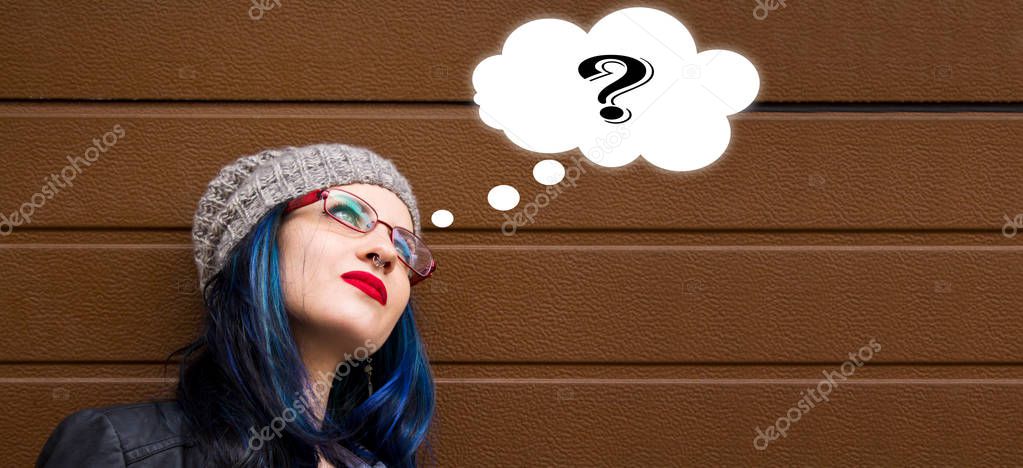 Mujer joven en una pose reflexiva con signos de interrogación 2024