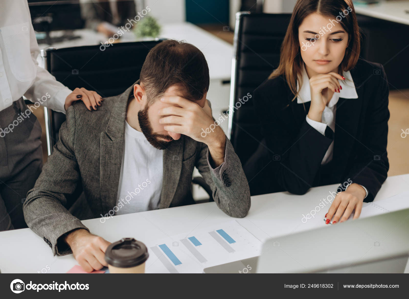 Sad man sitting at the desk in office looking at laptop screen having ...