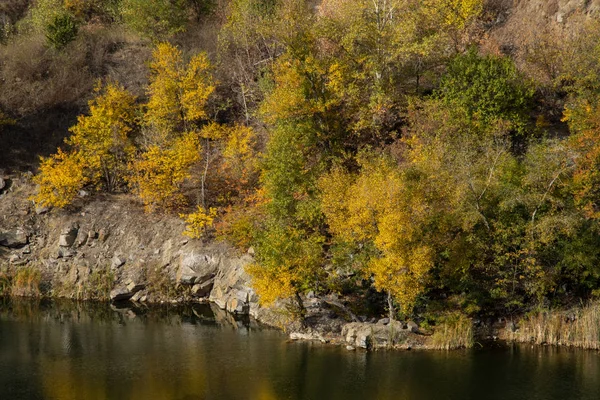 quarry filled with water surrounded by autumn trees in Ukraine in the ...