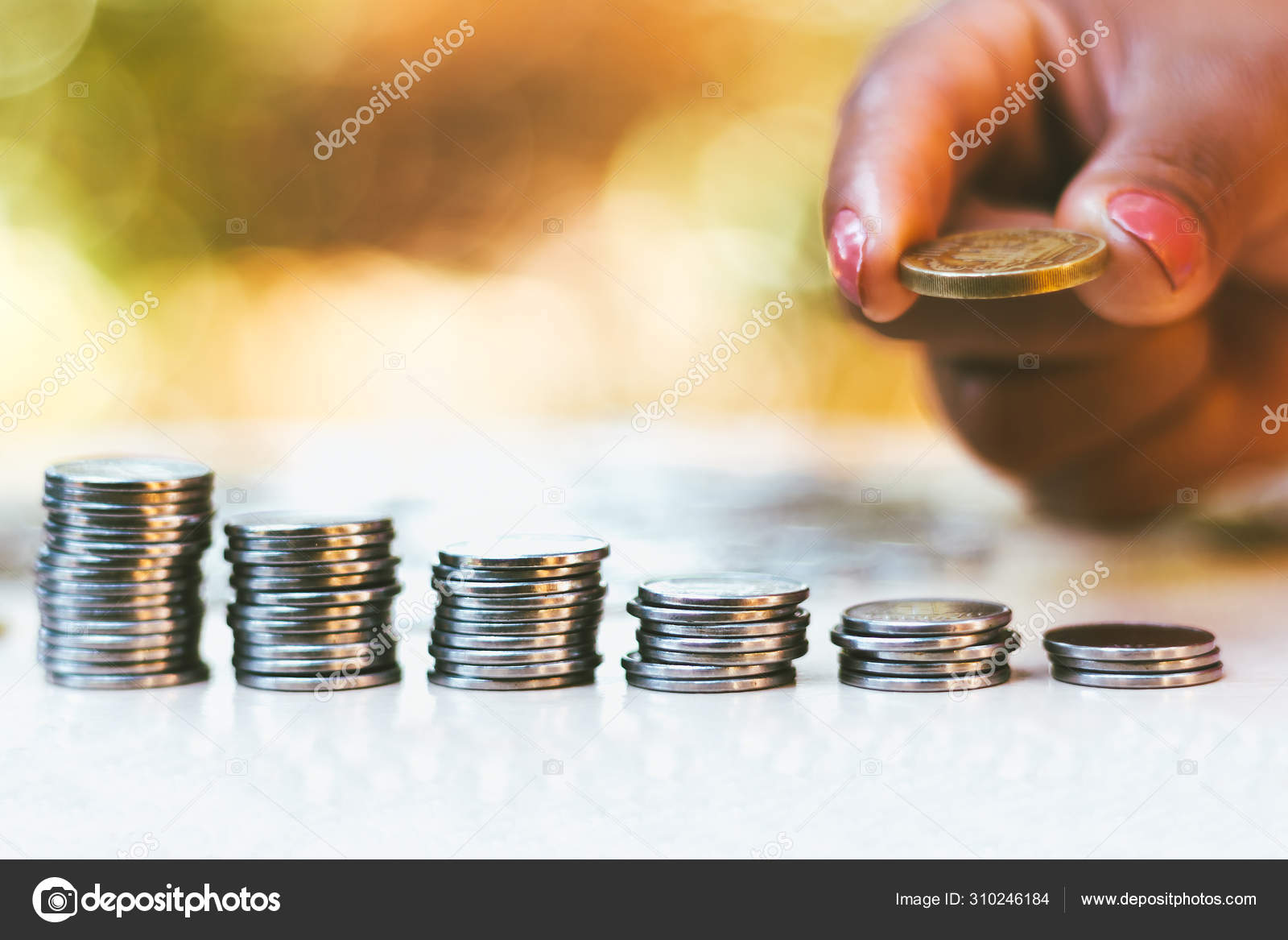 Woman raises coin stack on blurred background and copy space ...