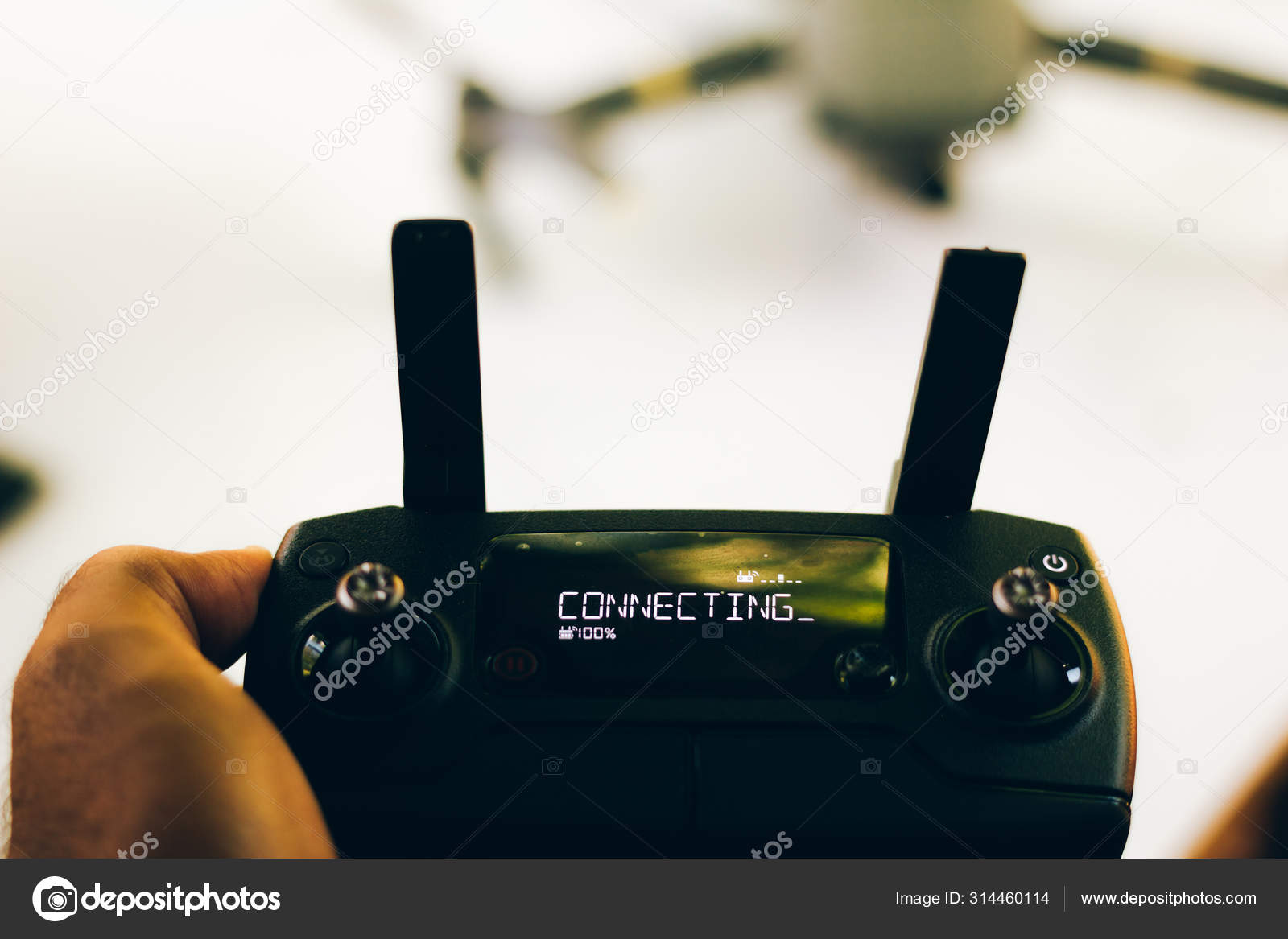 Drone pilot holds remote control with inscription plugging in display ...