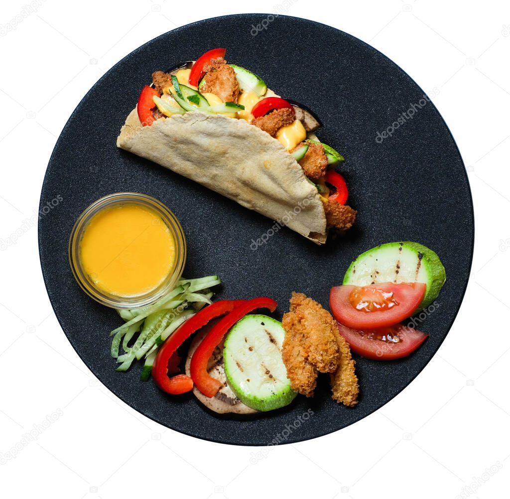 Taco caliente con ingridientes y salsa en el plato negro aislado 2022