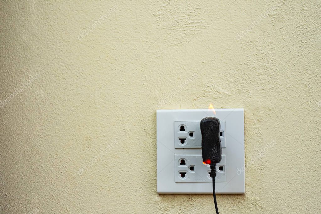 Enchufe de cable eléctrico al fuego Receptáculo y adaptador en la partición, fallo de ...