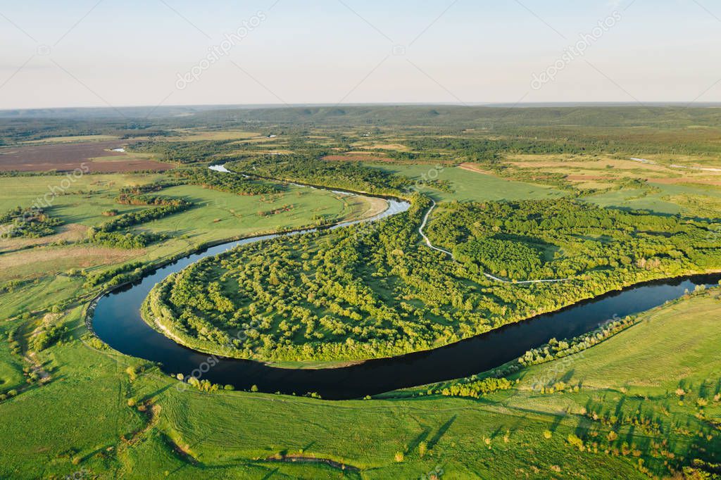 Vista aérea del sinuoso río Sura entre verdes llanuras y árboles ...