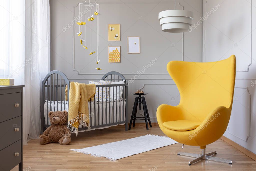 Elegante silla de huevo amarillo en el centro de la habitaci n infantil de moda en gris 2024