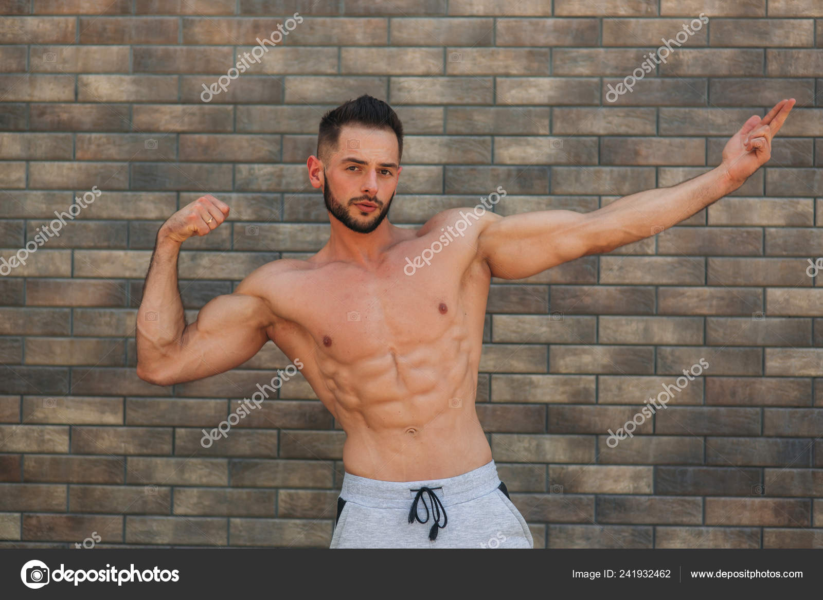 Young athlete posing with a torso for photography on a brick wall ...