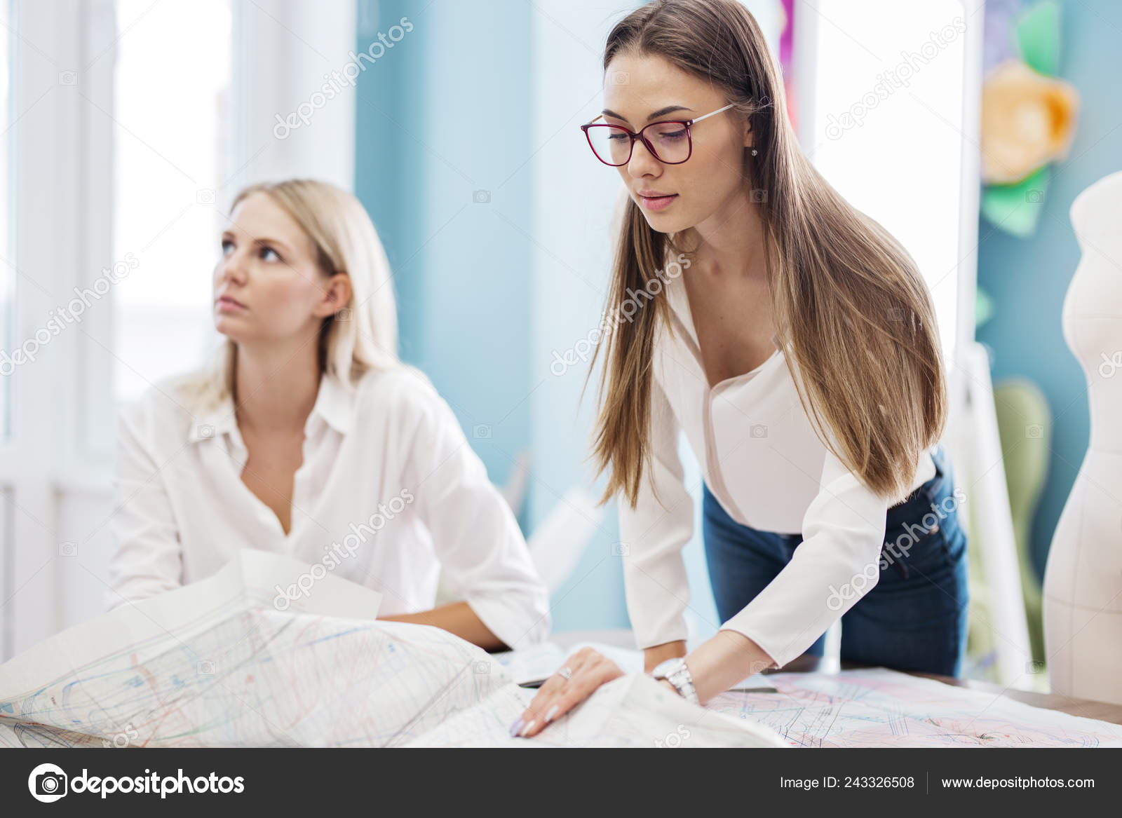 Two smart-looking pretty women wearing white shirts are pointing at the ...