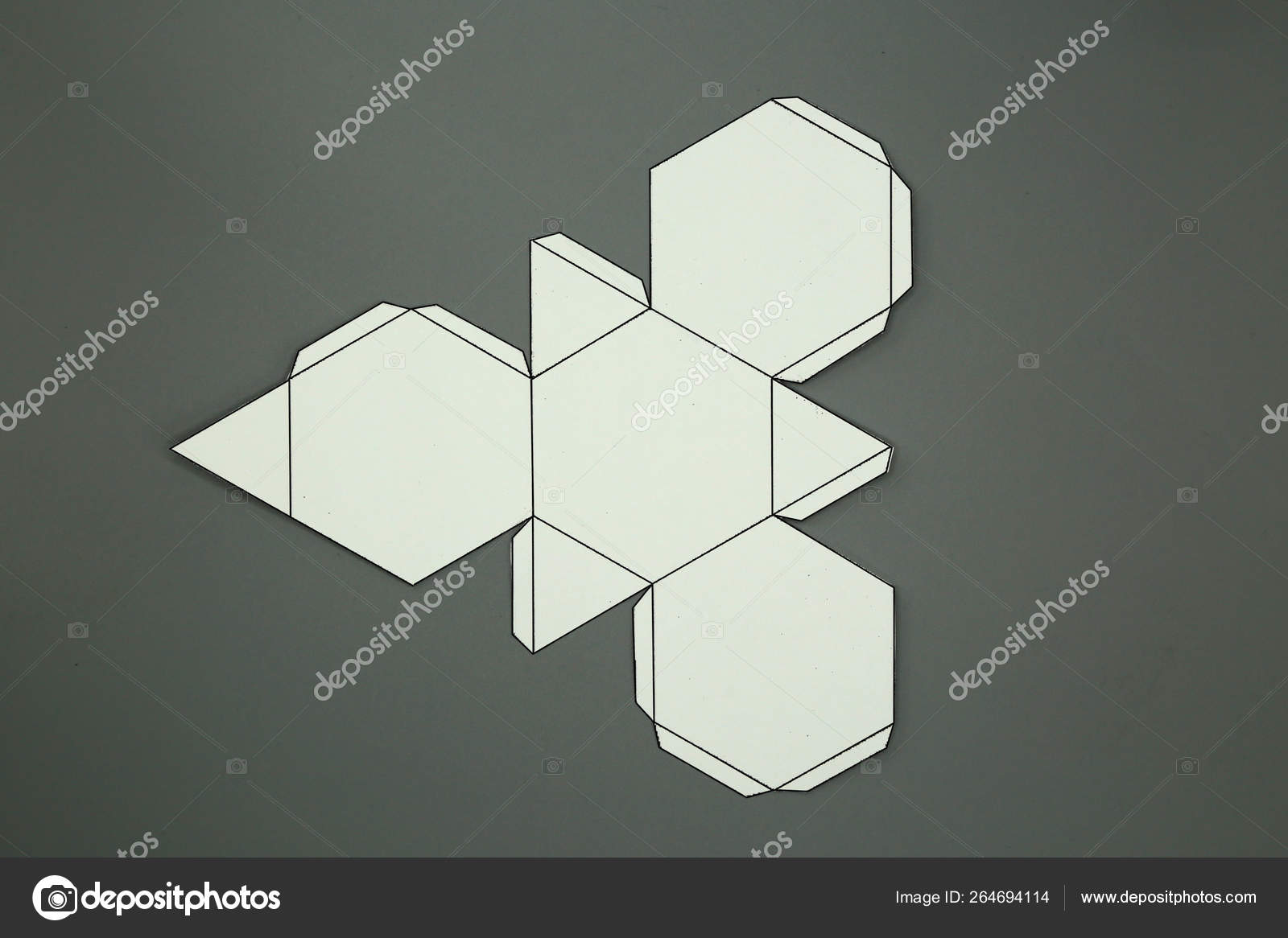 Geometric shape cut out of paper and photographed from above on grey ...