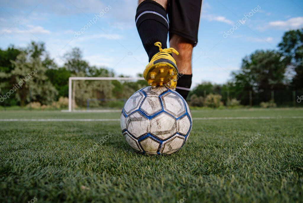 Primer plano del jugador de fútbol con pelota en el campo de futbol.Jugador de fútbol masculino ...