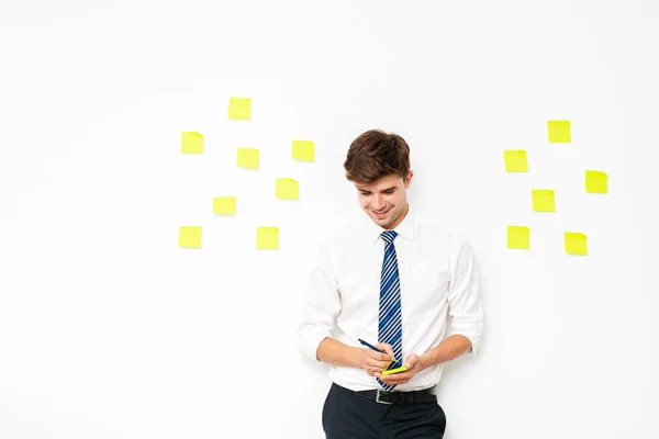 office guy at work, with post it on white wall, reminder notes, plans ...