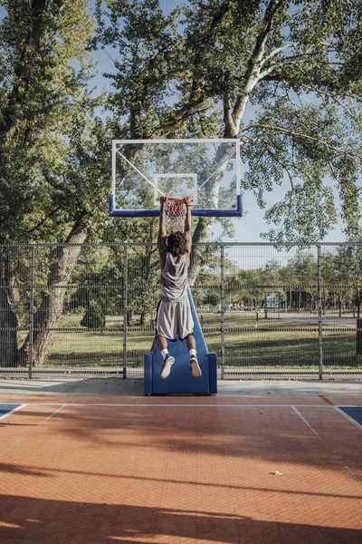 Back view of an African basketball player dunking a basketball and ...