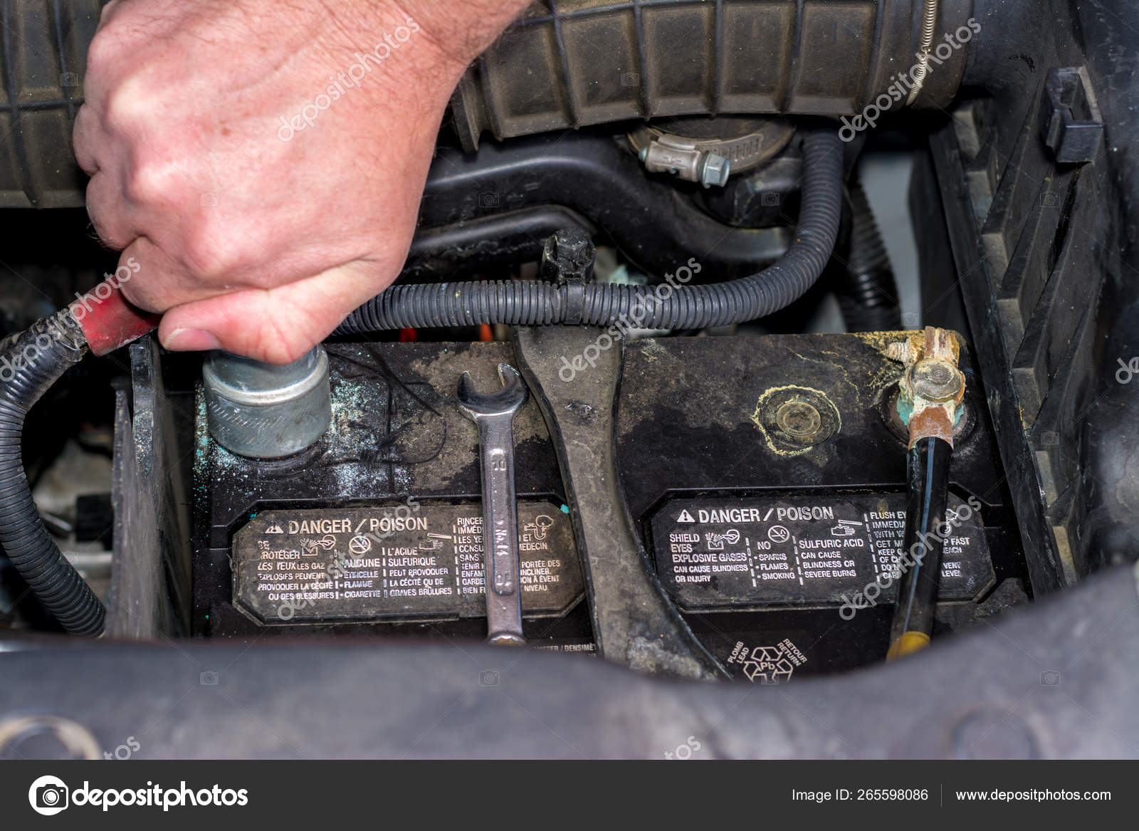 Man cleans the terminals of a battery in a truck Stock Photo by ...