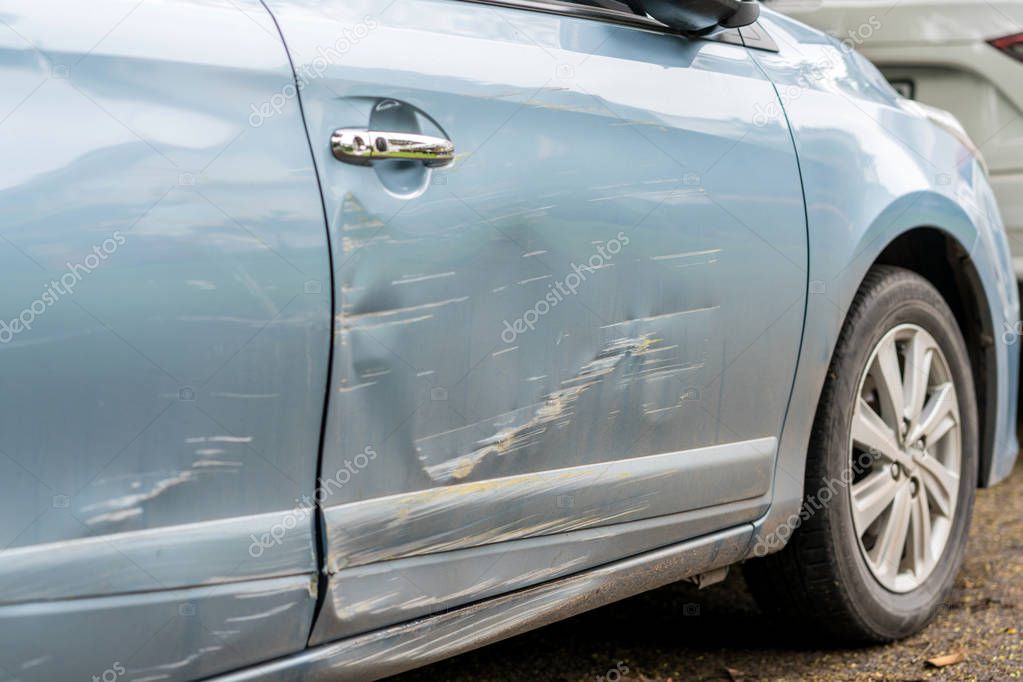 lado del coche está rayado y raspado con daños profundos a la pintura. 2023