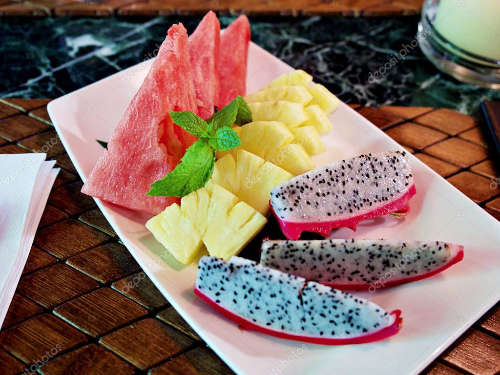 Surtido de frutas tropicales en un plato blanco, piña, fruta de dragón ...
