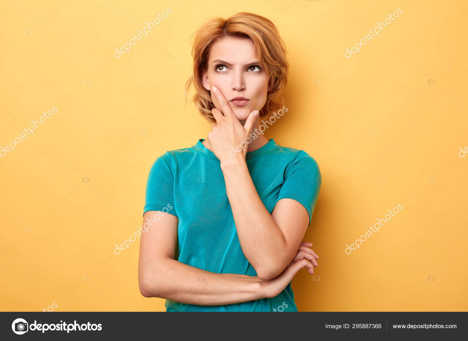 Elegante joven desconcertada mujer tocando su barbilla mirando hacia ...