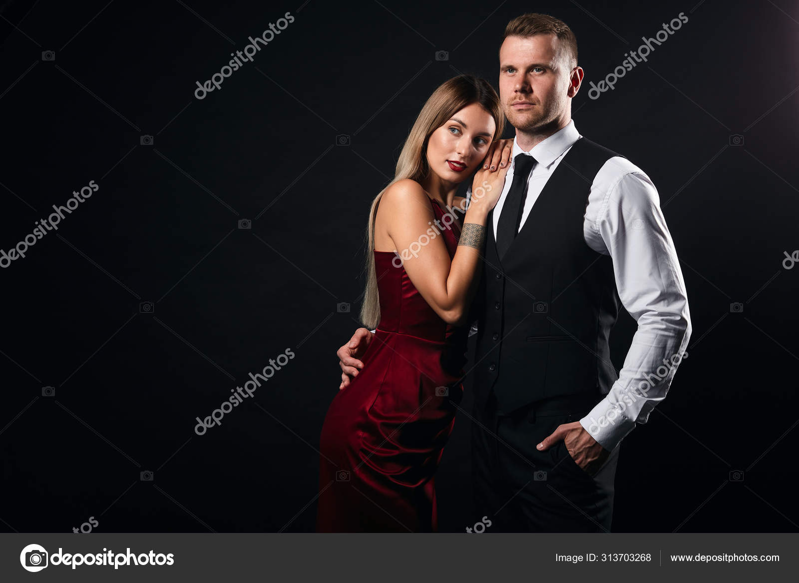 Serious strong man in elegant clothes hugging his woman Stock Photo by ...