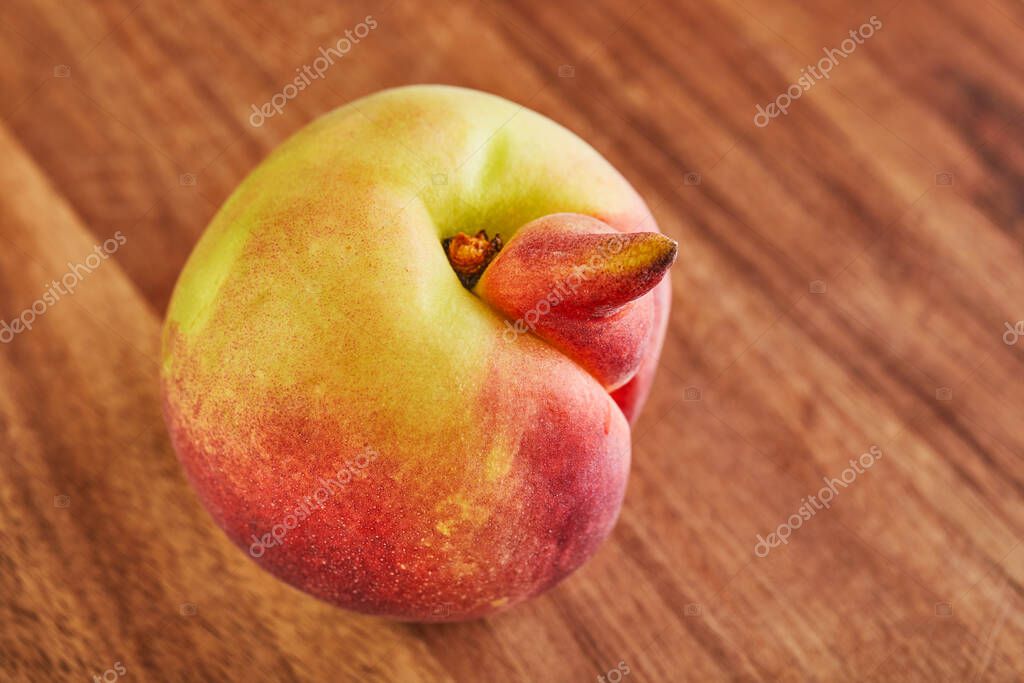 Fruta o verdura fea. Mutante durazno muy feo sobre un fondo de madera ...