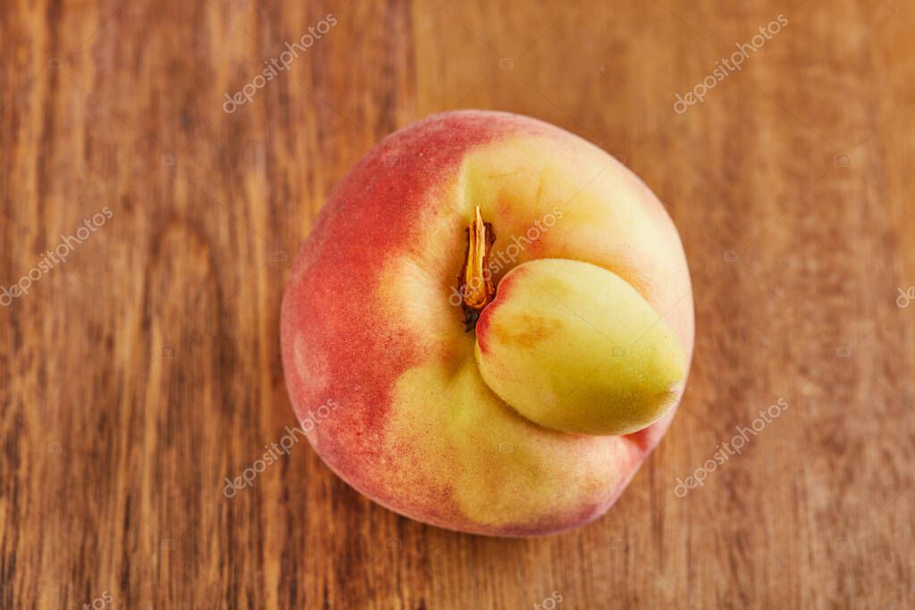 Fruta o verdura fea. Mutante durazno muy feo sobre un fondo de madera ...