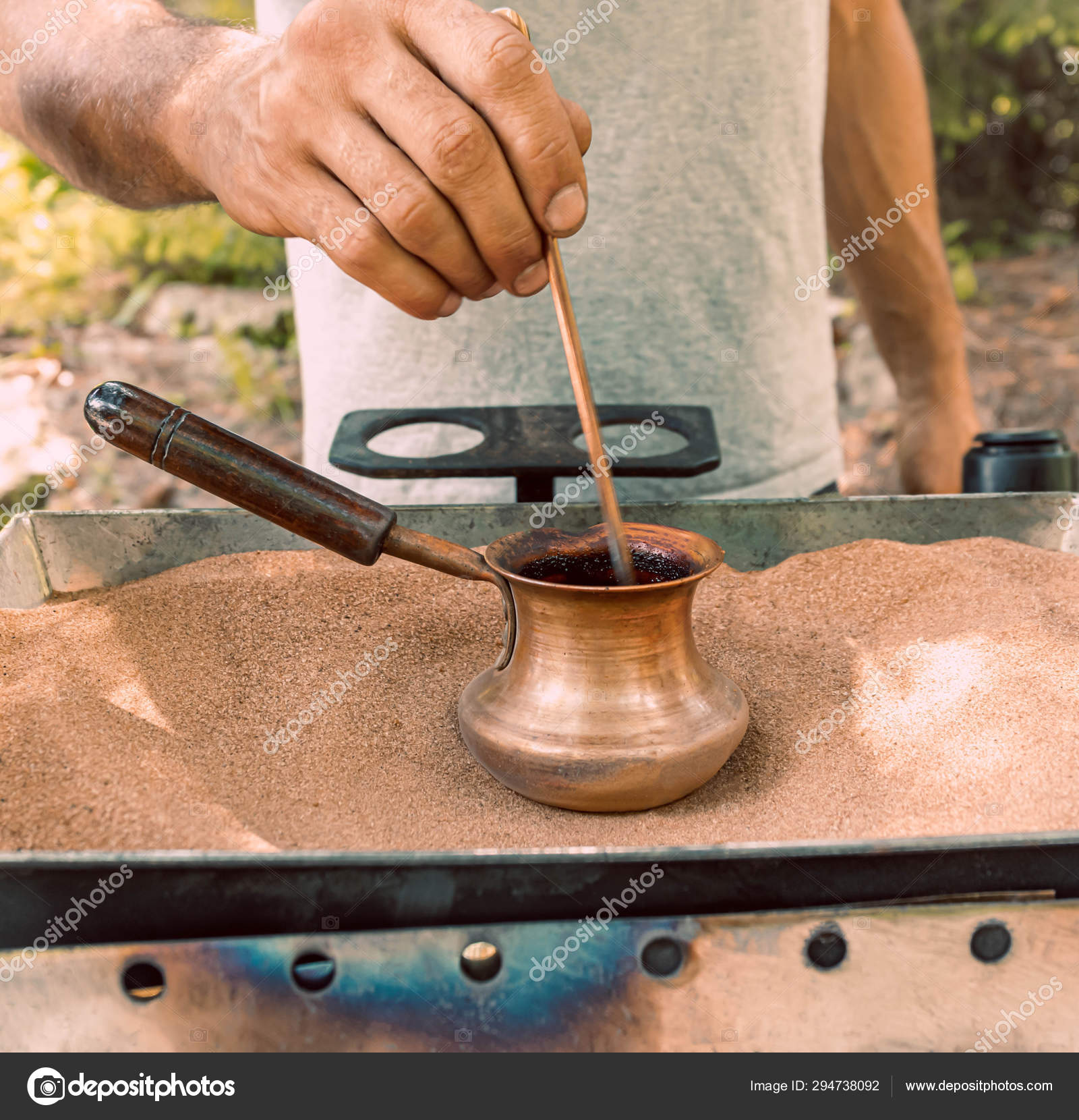 The process of making Turkish coffee on hot sand in a Turk. With ...