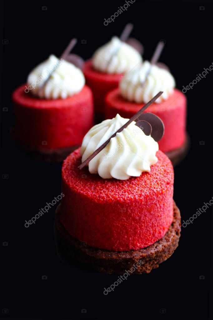 Cuatro postres de textura roja con tapa de crema y decoración de ...