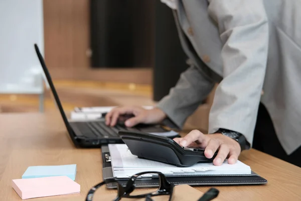 financial adviser working with calculator & computer at office ...