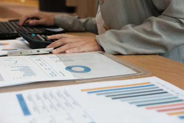 financial adviser working with calculator & computer at office ...