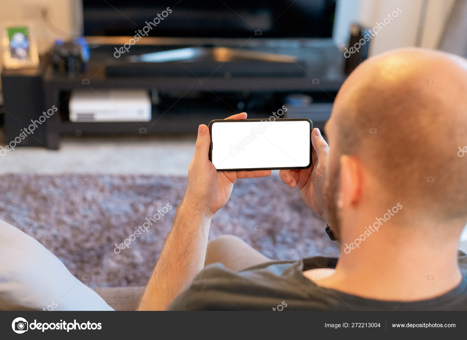 A white Caucasian male holds a black smartphone with a big white screen ...