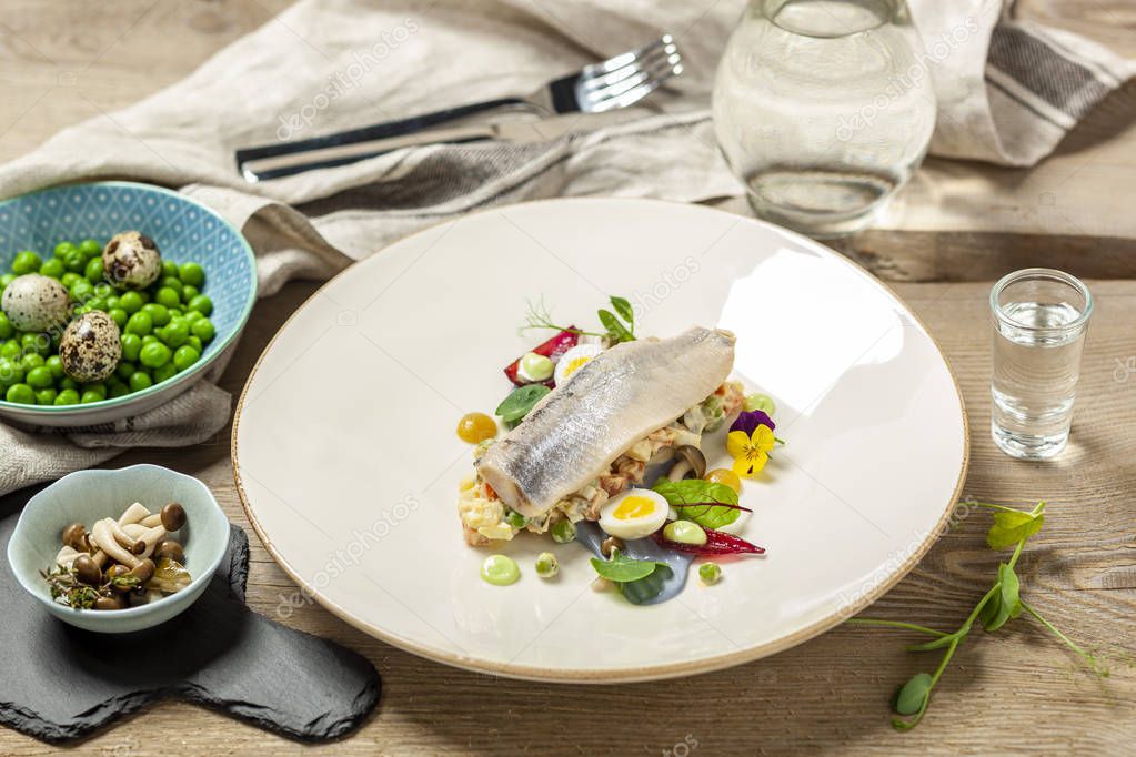 Arenque, crema agria ahumada, cebolla marinada en vinagre de chalota y ...