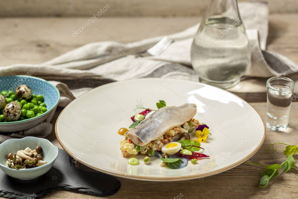 Arenque, crema agria ahumada, cebolla marinada en vinagre de chalota y ...