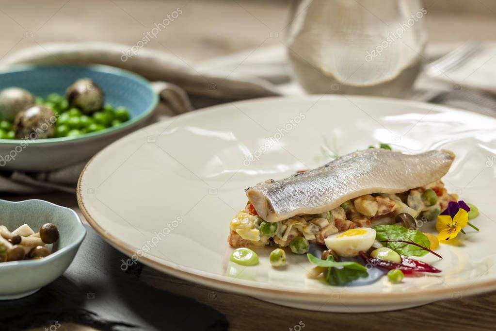 Arenque, crema agria ahumada, cebolla marinada en vinagre de chalota y ...