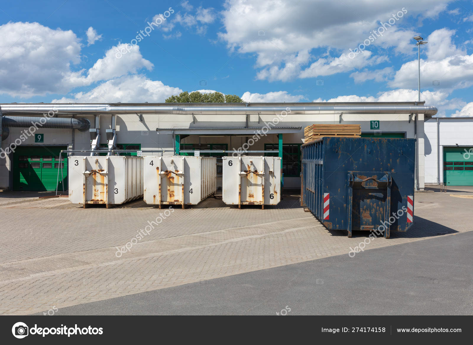 White garbage containers are standing on a factory site and ther Stock ...