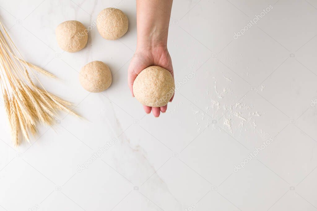 Vista superior de la mano femenina sosteniendo masa de pan moldeado en ...