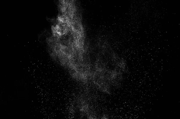 Freeze motion of white particles on black background. Powder explosion. Abstract dust overlay ...