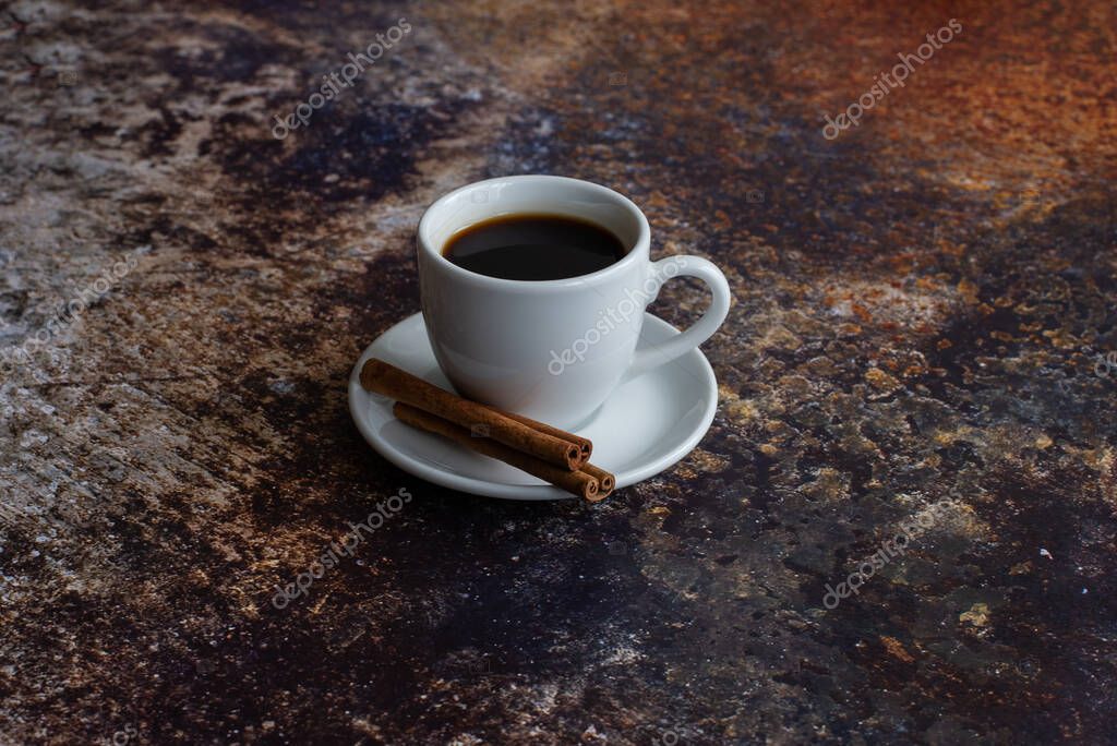 Taza blanca de café con un platillo con palitos de canela sobre un ...