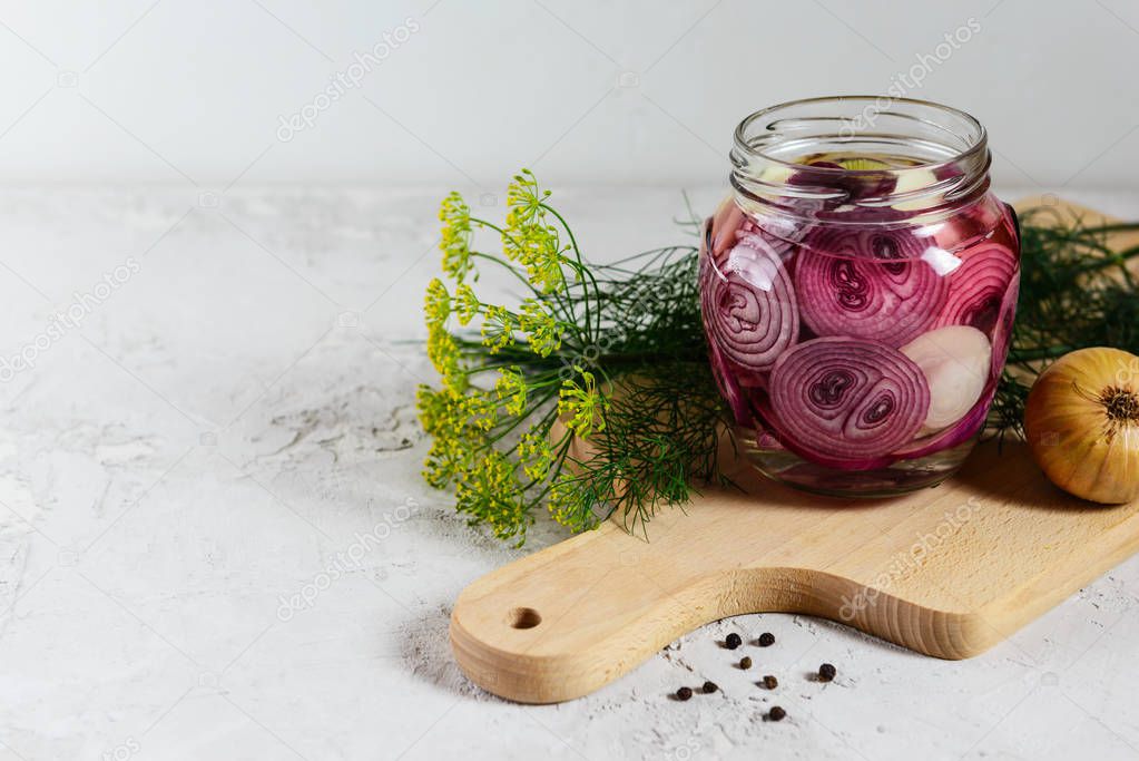 Cebollas en escabeche en un frasco sobre una tabla de madera. Comida ...