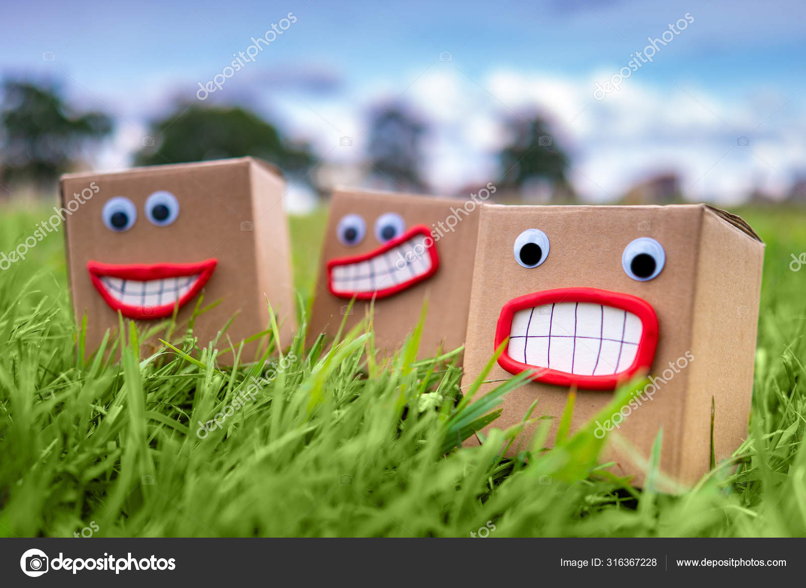 Emoji box. Cardboard boxes on the green grass. Packaging expresses ...