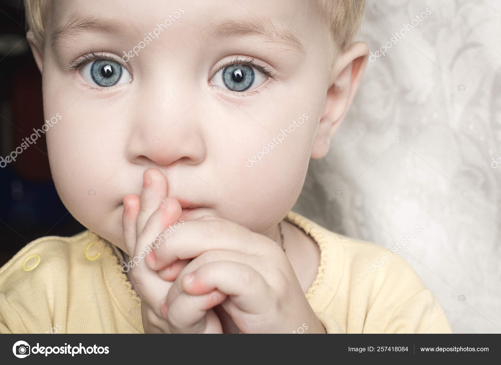 Beautiful child bites his fingers in his mouth Stock Photo by ©Tagwaran ...