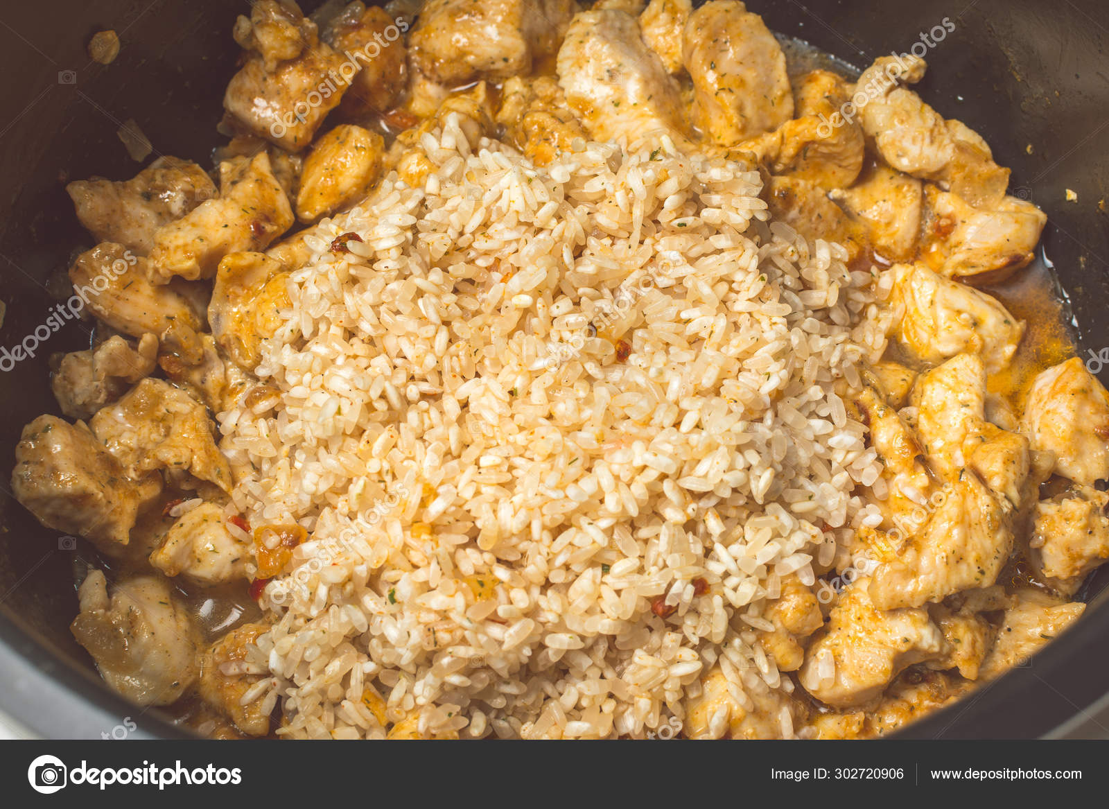 Laying wild rice and chicken pieces for making pilaf in slow cooker ...