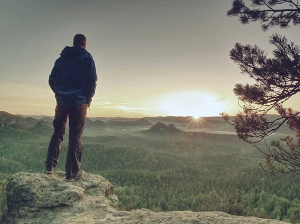 Slim guy on peak watching over valley to rising Sun - Stock Image ...